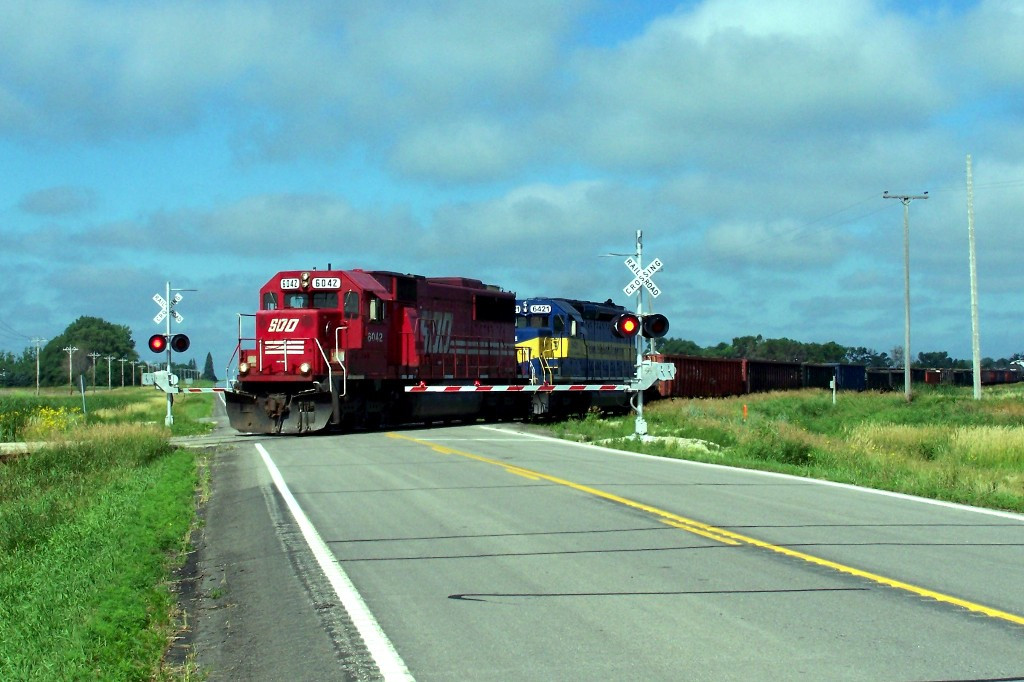 Soo 6042 crosses a local road headed east